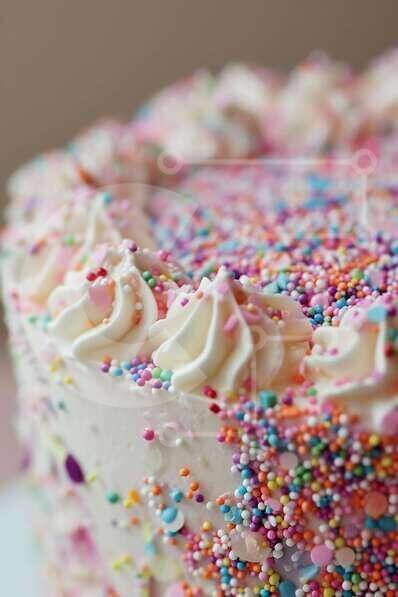 Colorful Sprinkle Cake with White Icing stock photo | Creative Fabrica